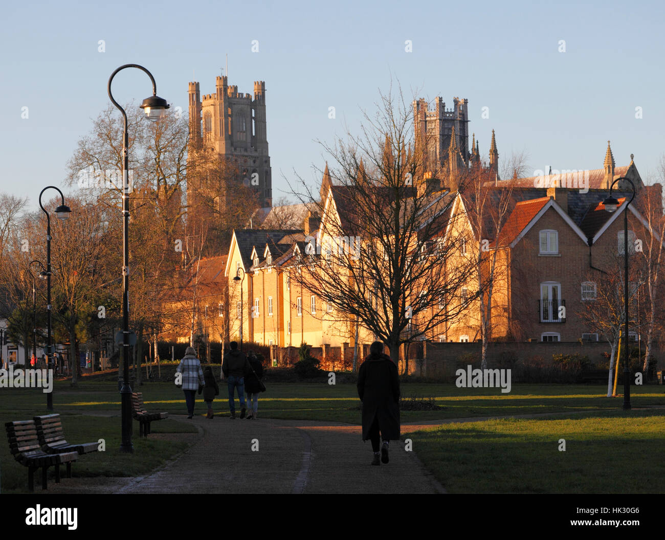 Pedestrians walk through Jubilee Gardens in Ely with the Cathedral seen ...