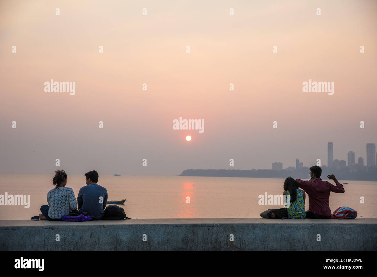 Couples watch the sunset over Chowpaty Beach in Mumbai (Bombay), India ...
