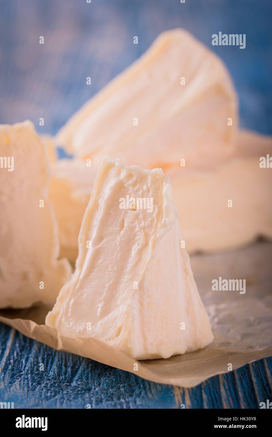 Vertical photo of several portions of camembert. Cheese is cut to ...