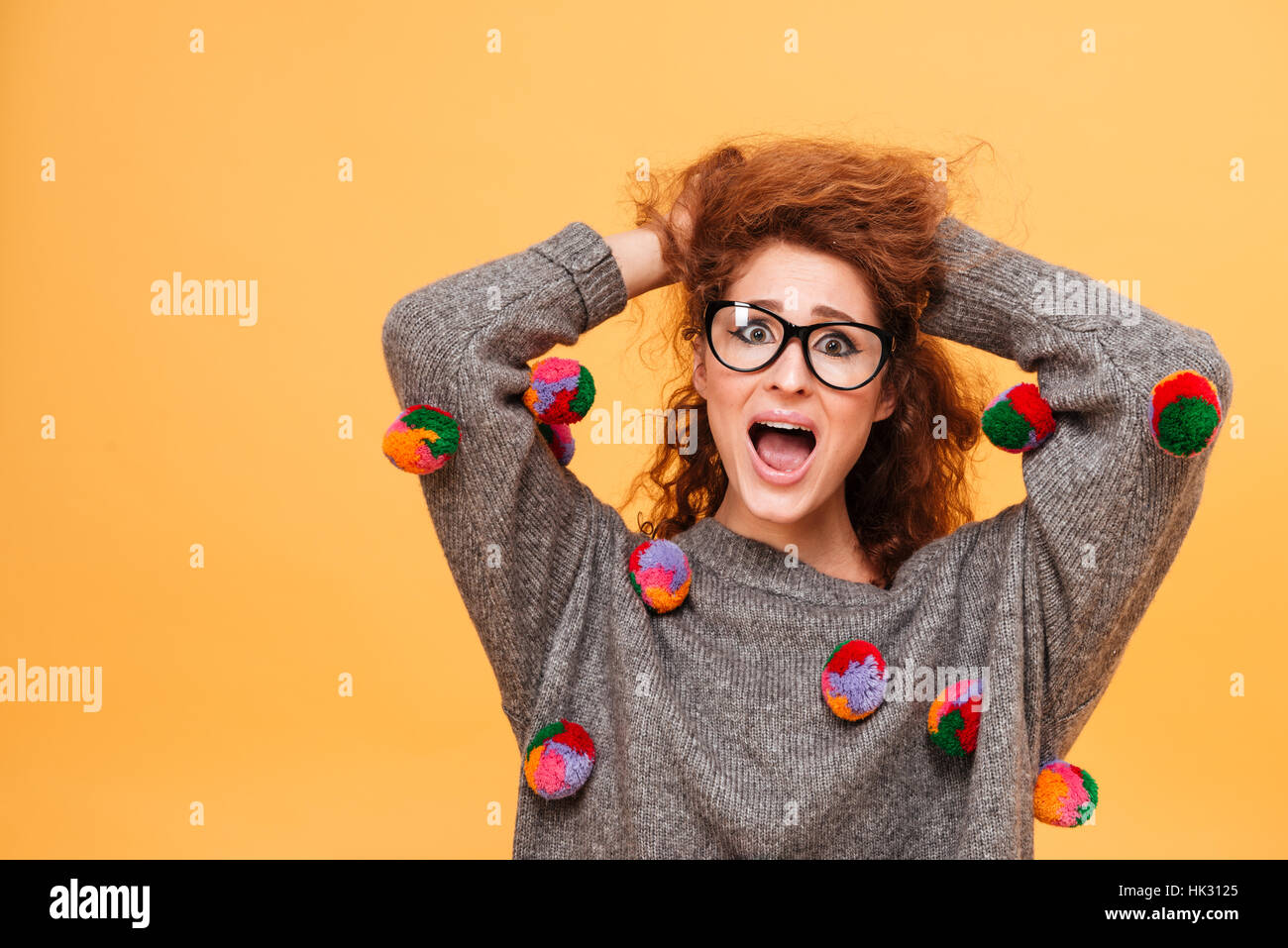 Beautiful young redhead woman screaming with hands in her hair isolated ...