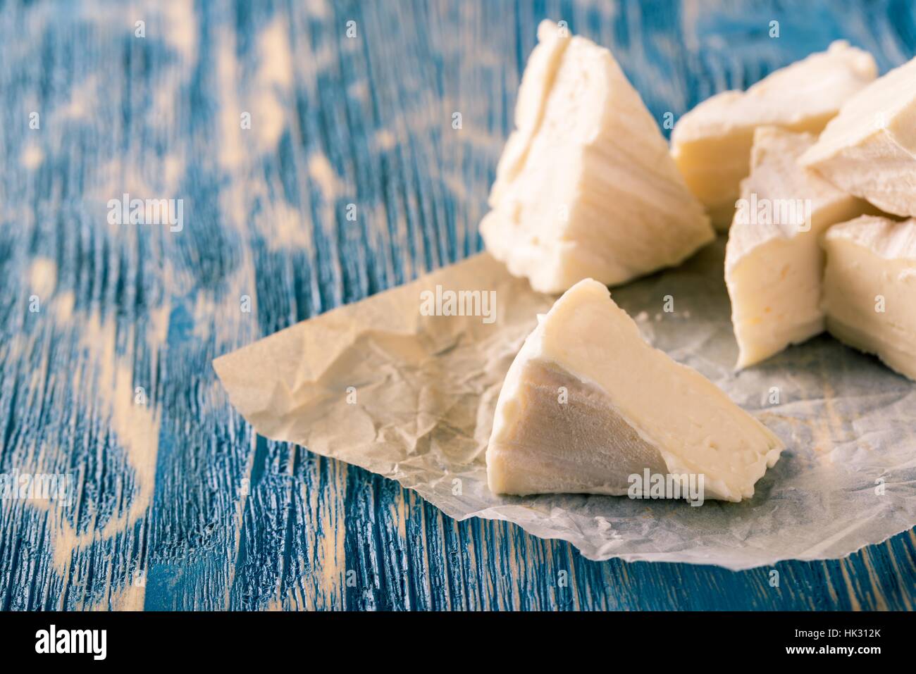 Horizontal photo of several portions of camembert. Cheese is cut to ...