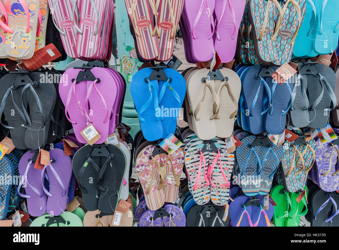 A display of rubber flip-flops and thong sandals in front of a shop on ...