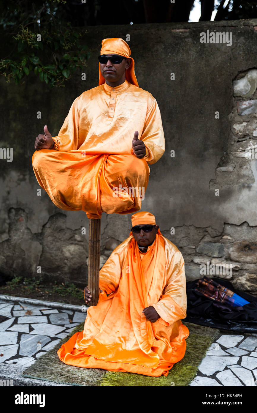 Two street entertainers perform a levitation illusion, Pisa, Tuscany ...