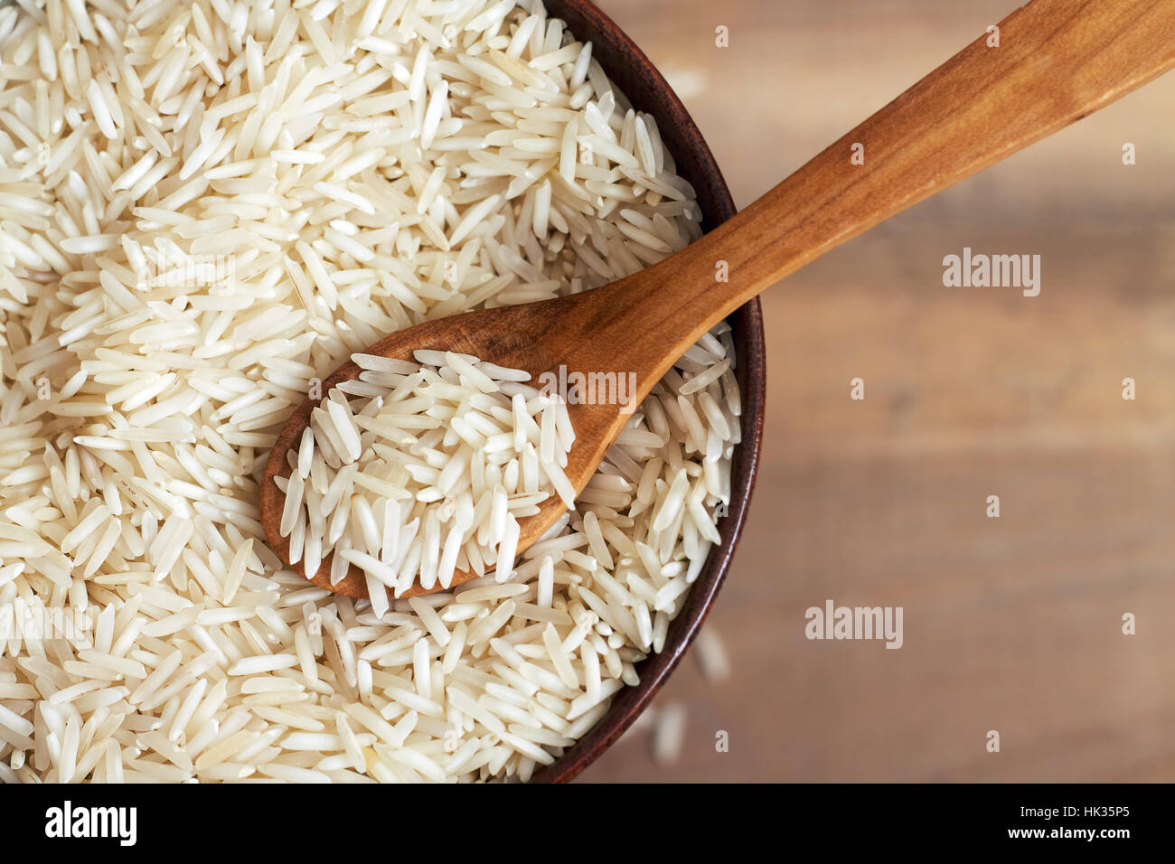 Raw uncooked basmati rice in wooden bowl. Top view with copy space ...