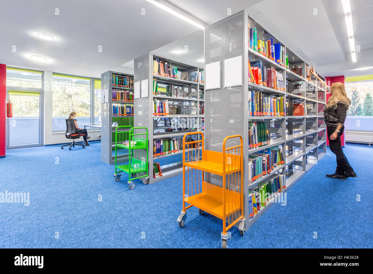 Light library interior with modern shelves and colorful trolley Stock ...
