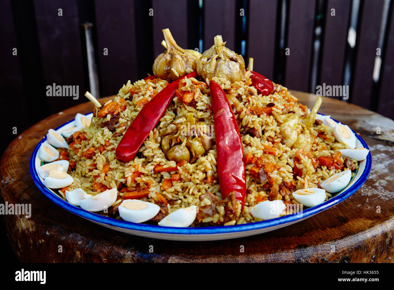 National Uzbek dish pilaf. Cooking in a cauldron on fire. Spread ...