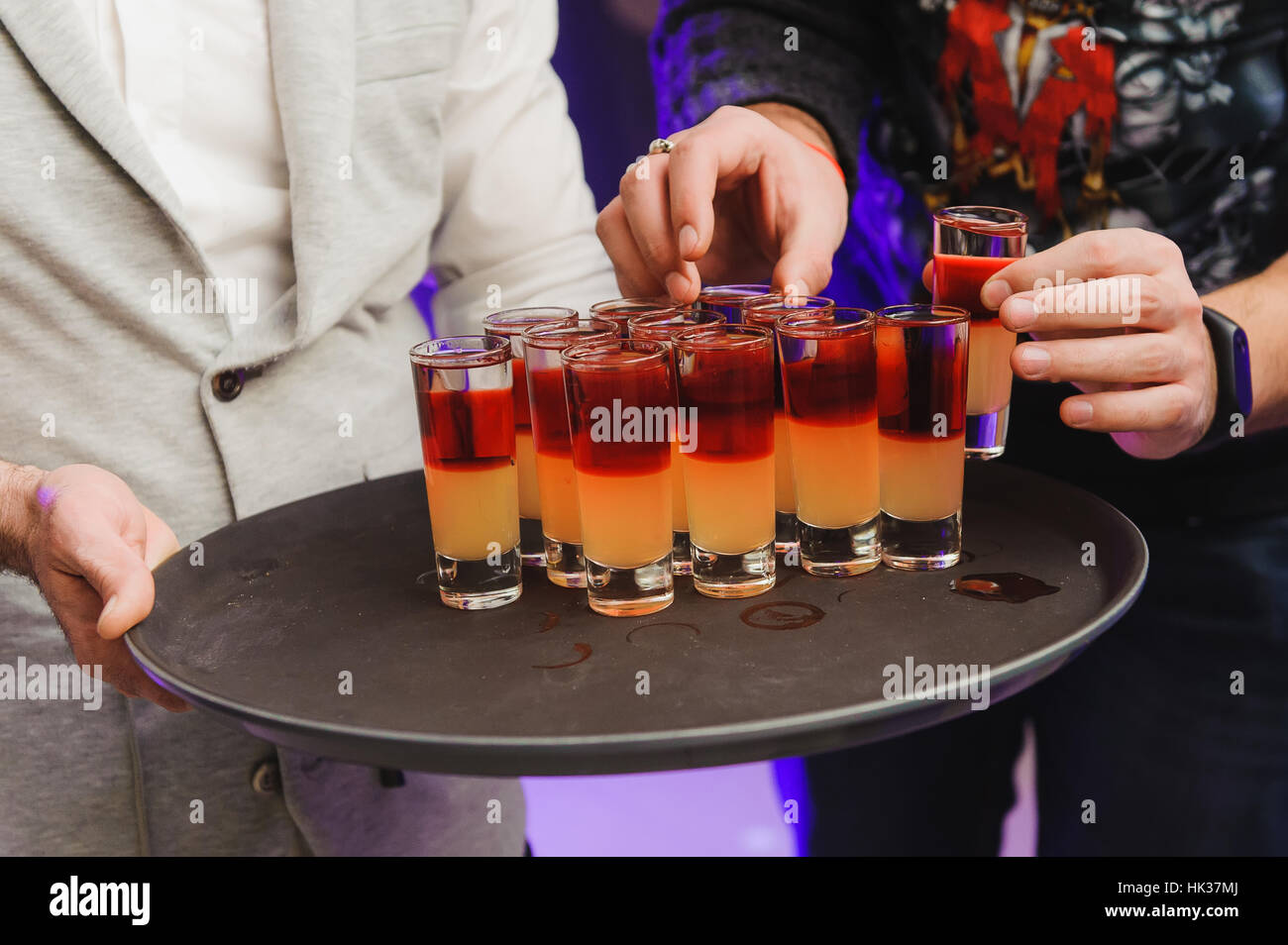 Drinking at a party. Waiter offering cocktail to guests at party, close ...