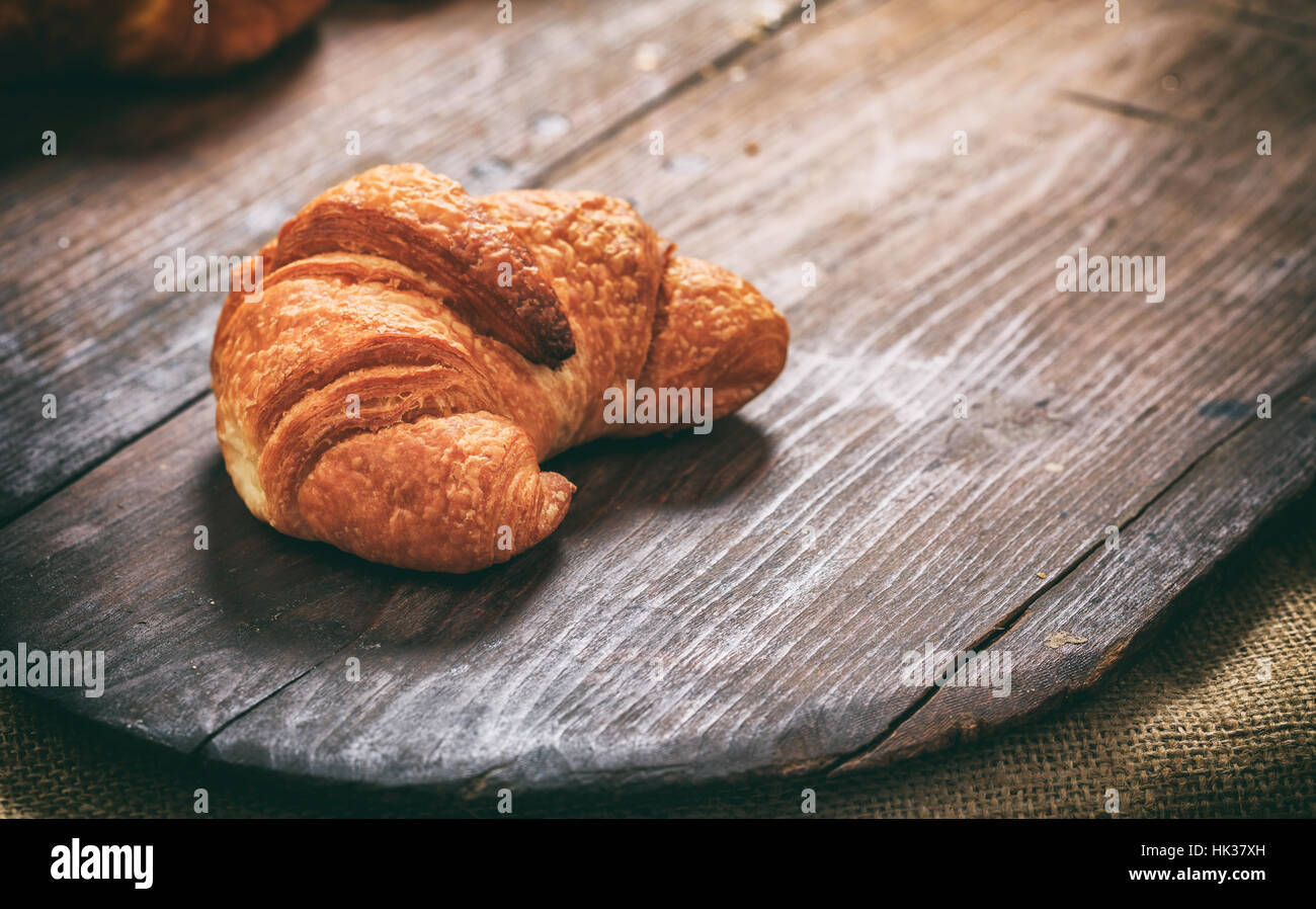 Croissant on an old wooden baker's peel Stock Photo - Alamy