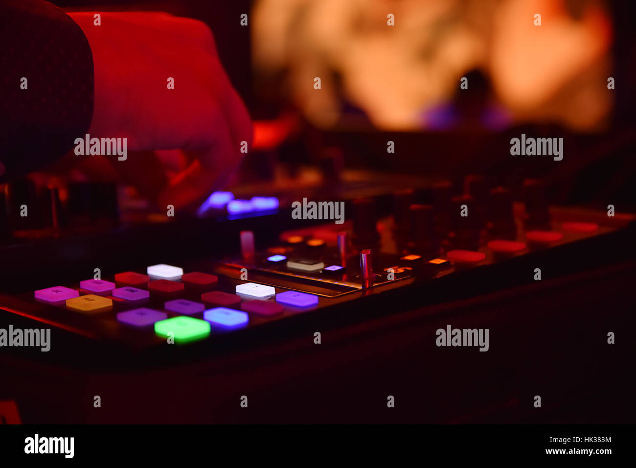 Dj playing mixing console in nightclub with colored lights Stock Photo ...