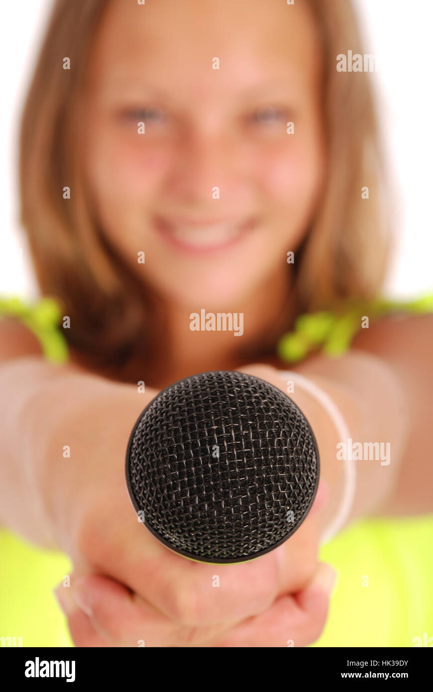 Teenage girl holding a microphone in front. Focus on the microphone ...