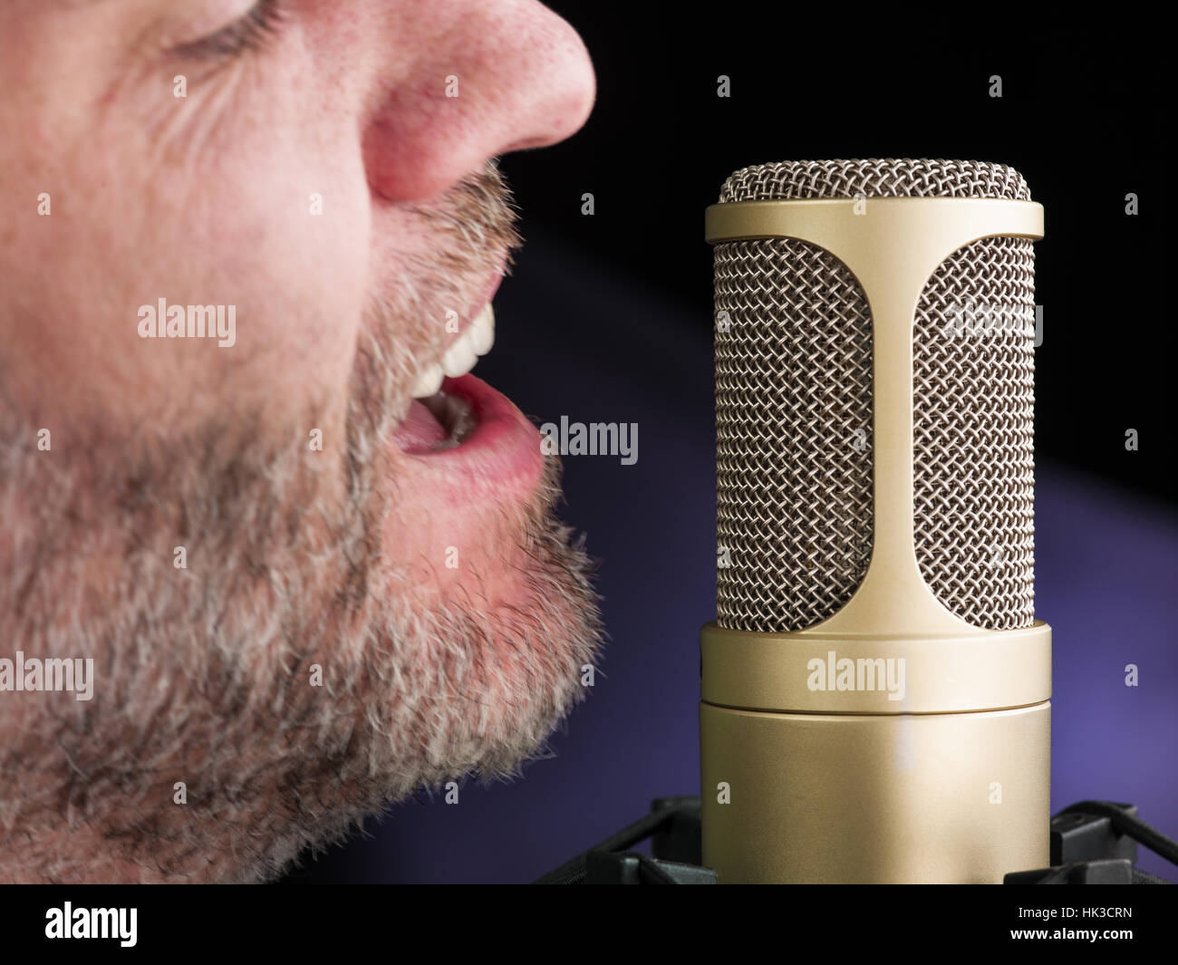 golden broadcast voice microphone on dark background - closeup shot ...