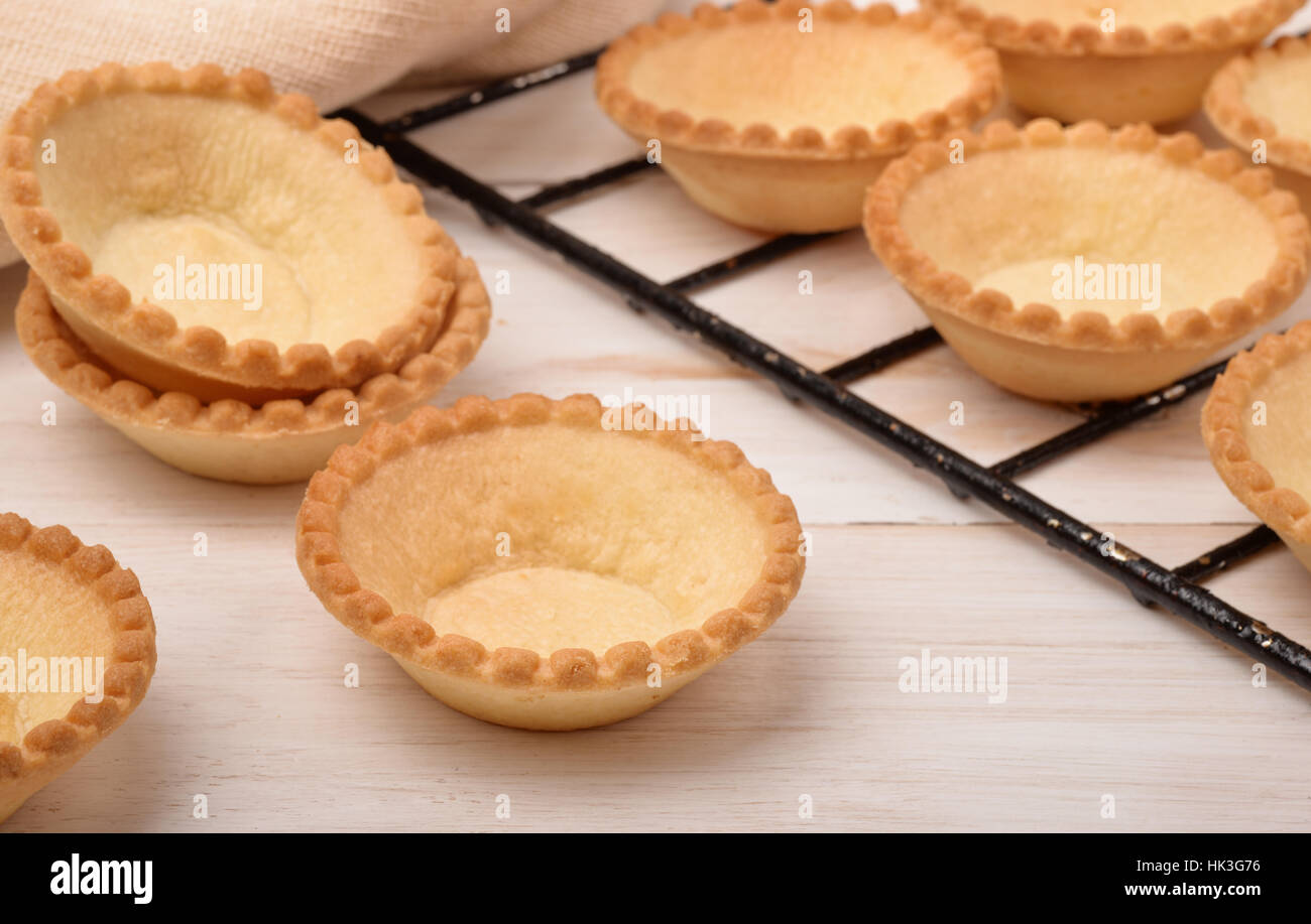 Group of fresh baked empty tart shells on wooden table Stock Photo - Alamy
