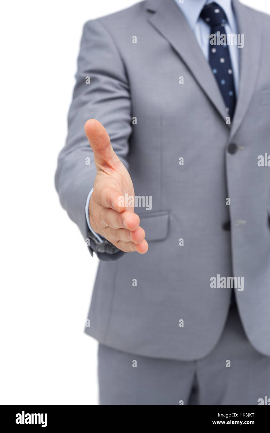 Businessman giving a hand at the camera against white background Stock ...