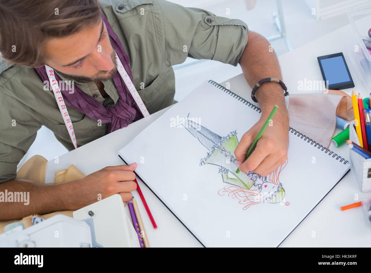Fashion designer creating a coat for woman with pencils Stock Photo - Alamy