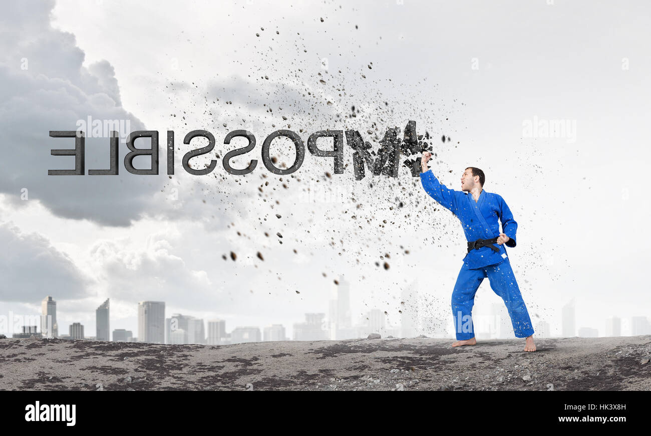 Young determined karate man breaking stone impossible word hi-res stock ...