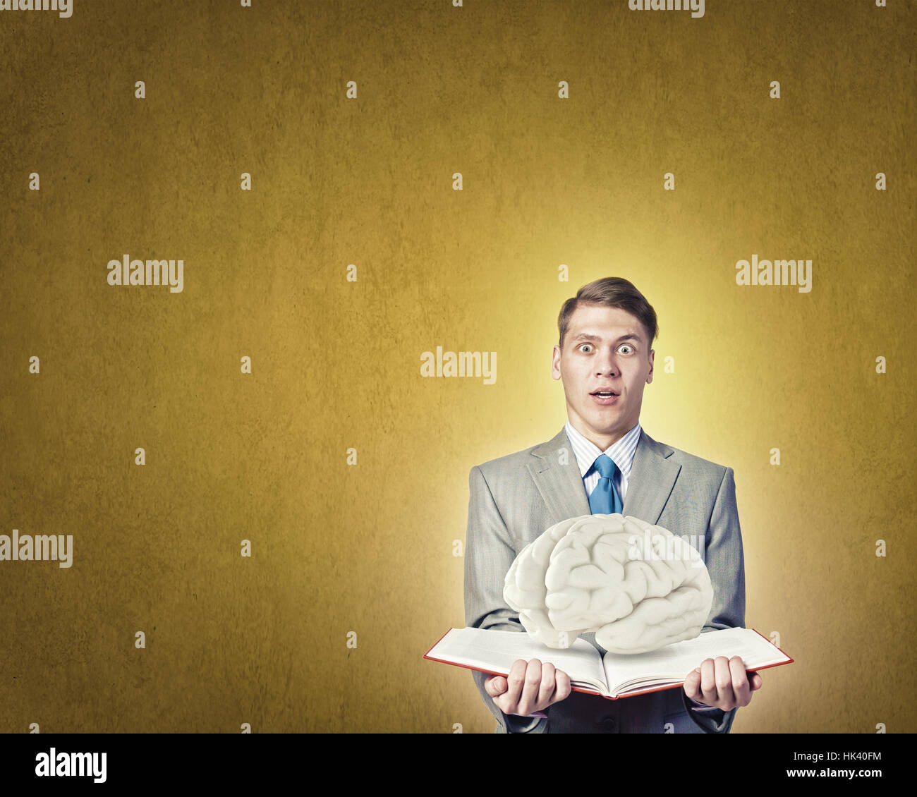 Shocked businessman holding opened book with brain picture Stock Photo ...