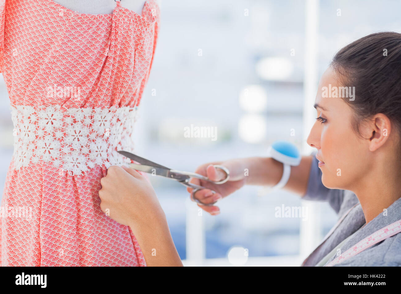 Fashion designer cutting dress with scissors Stock Photo - Alamy