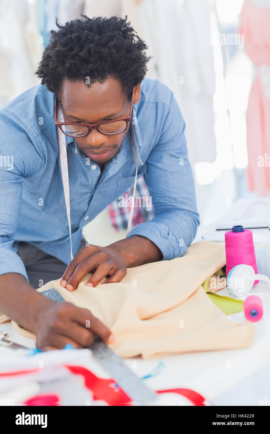 Attractive fashion designer measuring textile with a ruler Stock Photo ...
