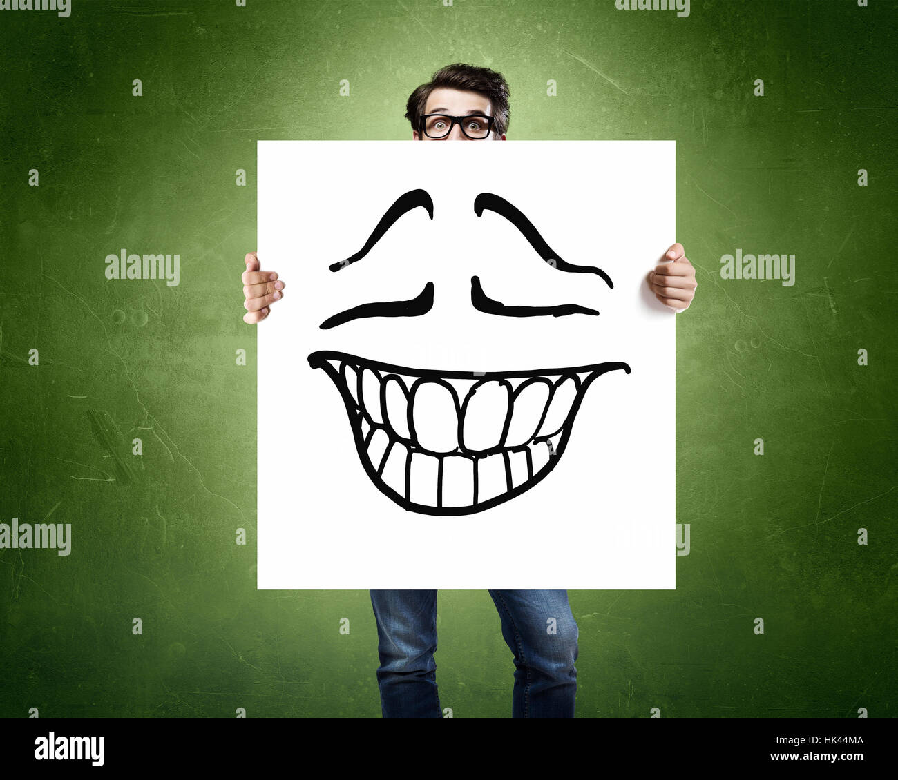 Businessman holding and hiding behind card with smiley face emoticon ...