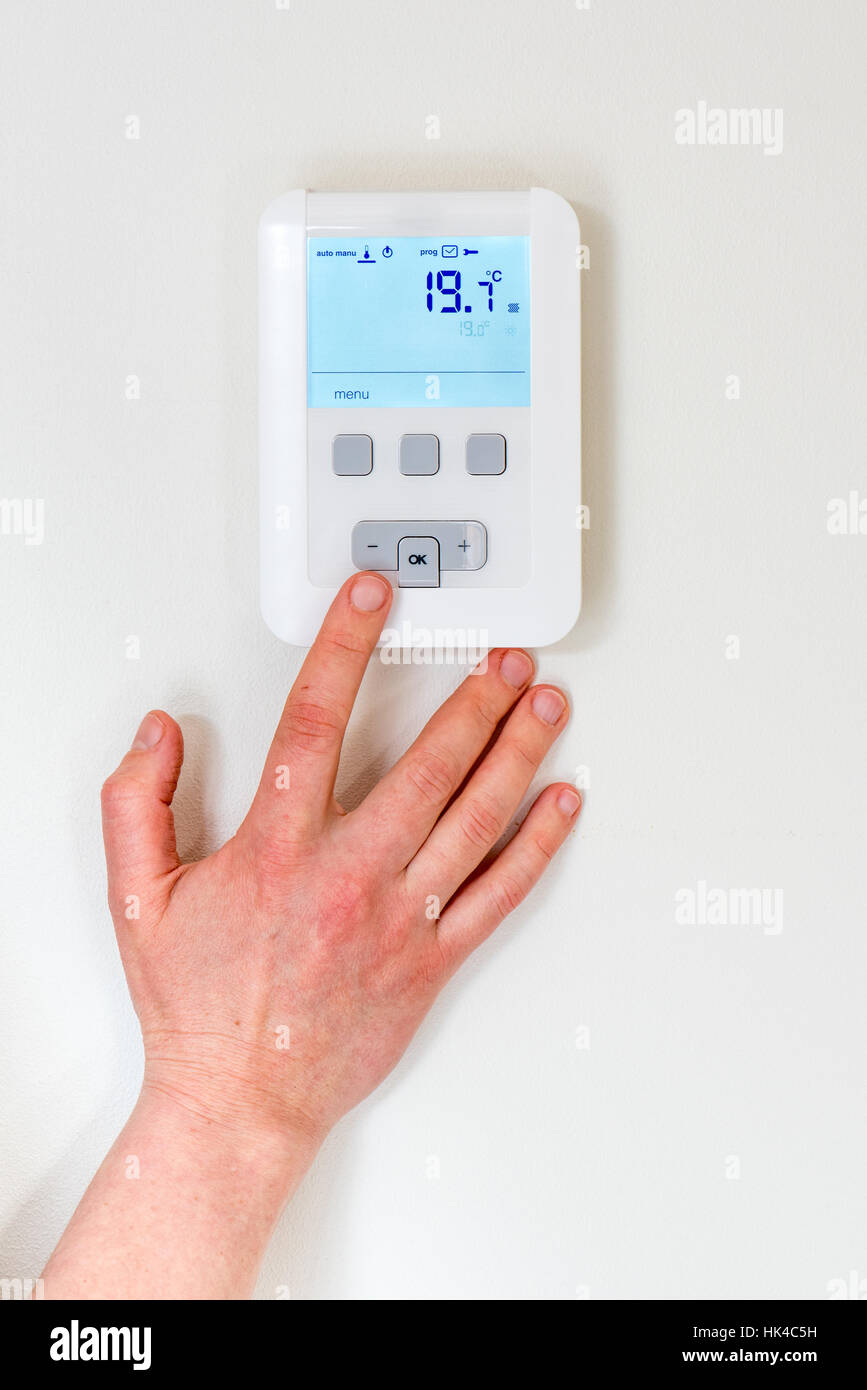 digital thermostat with finger pressing button Stock Photo - Alamy