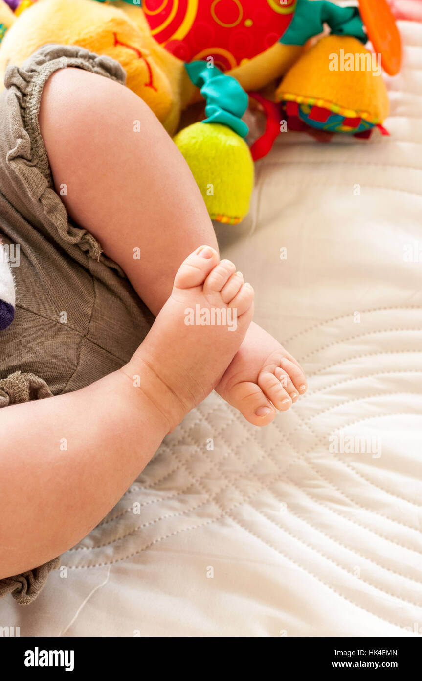 Baby's feet with soft toy Stock Photo - Alamy