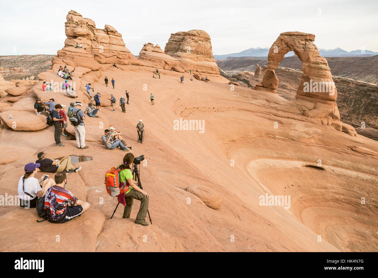 hikers gather around the delicate arch overlook at Arches National Park ...