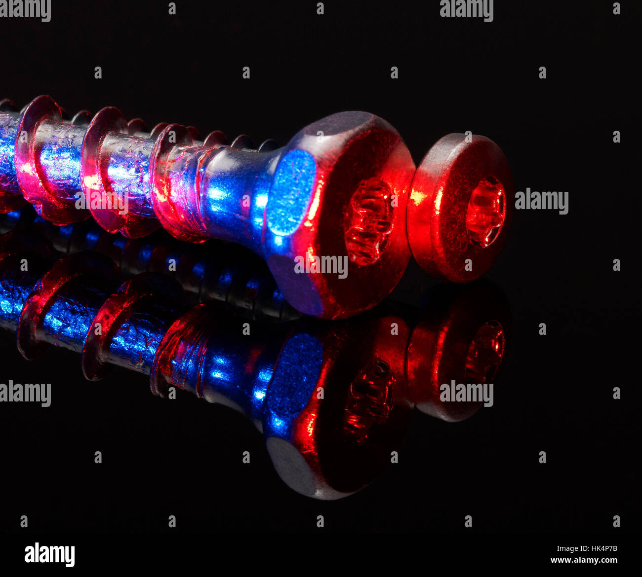some red and blue illuminated screws in black reflective back Stock ...