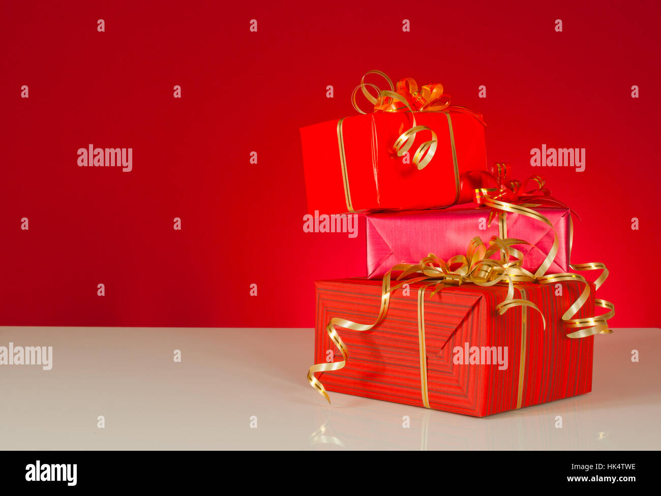 Three red presents against blue background Stock Photo - Alamy