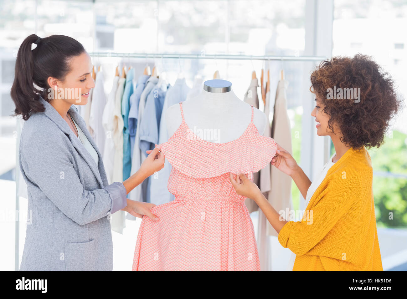 Attractive fashion designers adjusting a dress on a mannequin Stock ...