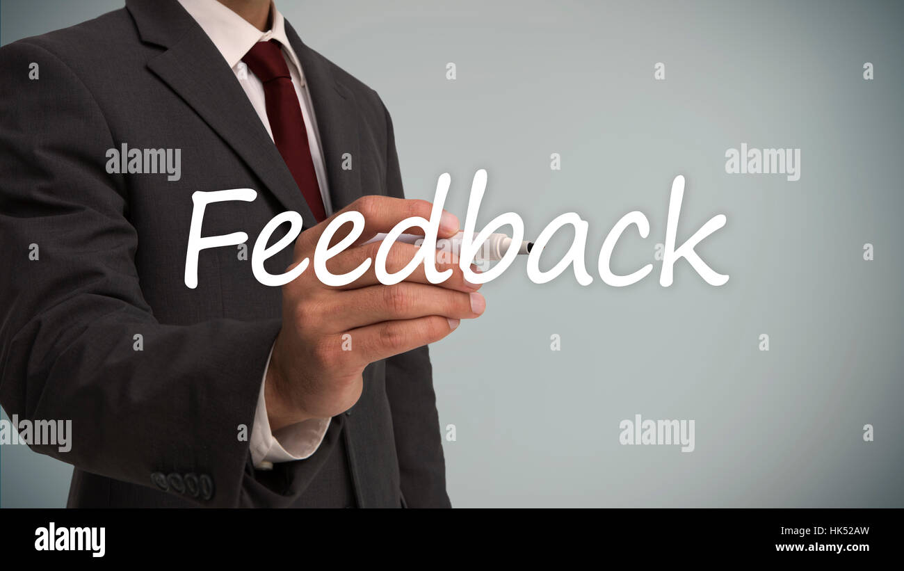 Businessman writing the word feedback on grey background Stock Photo ...