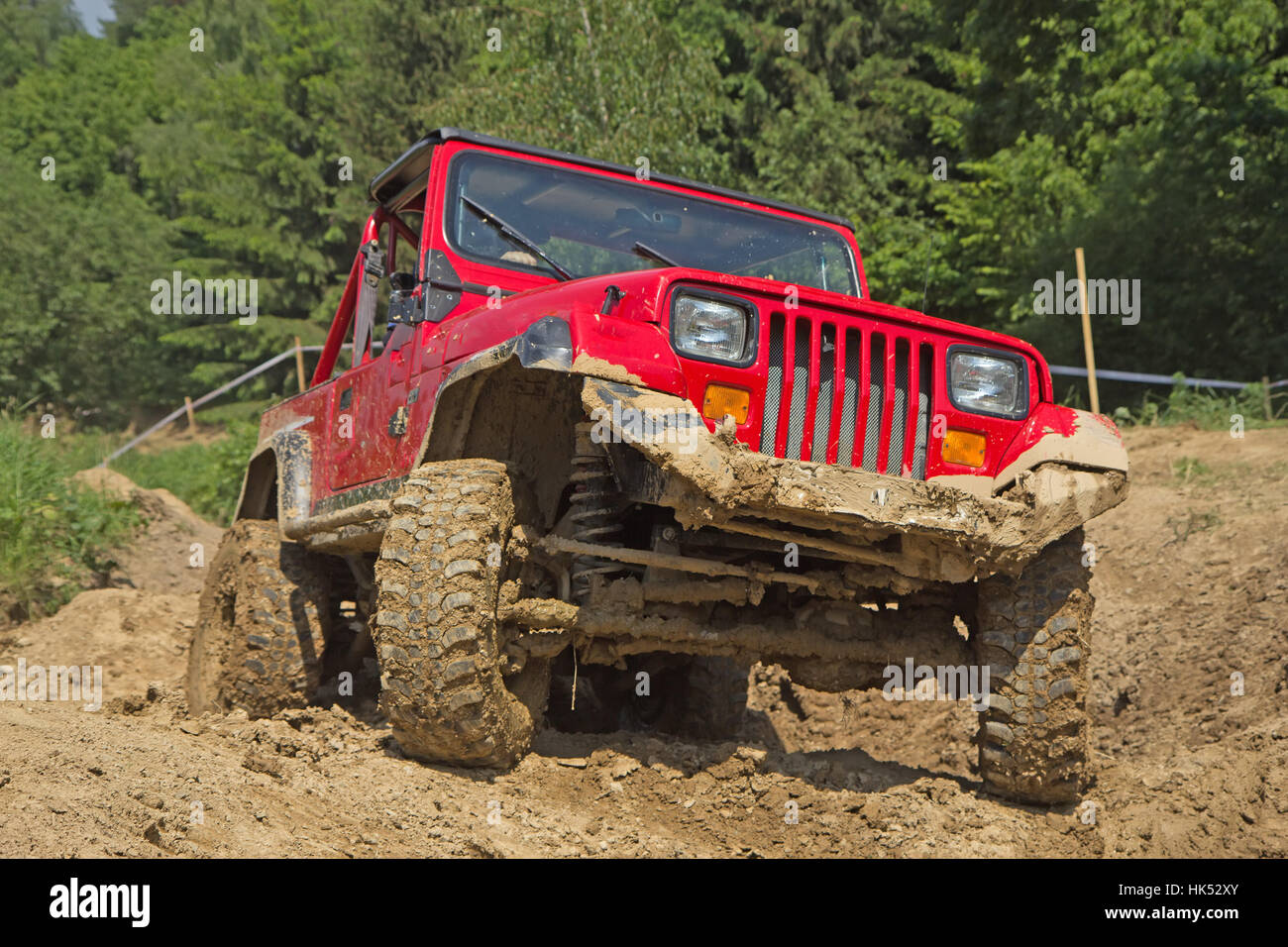 Red off-road vehicle in muddy terrain. All potential trademarks are ...