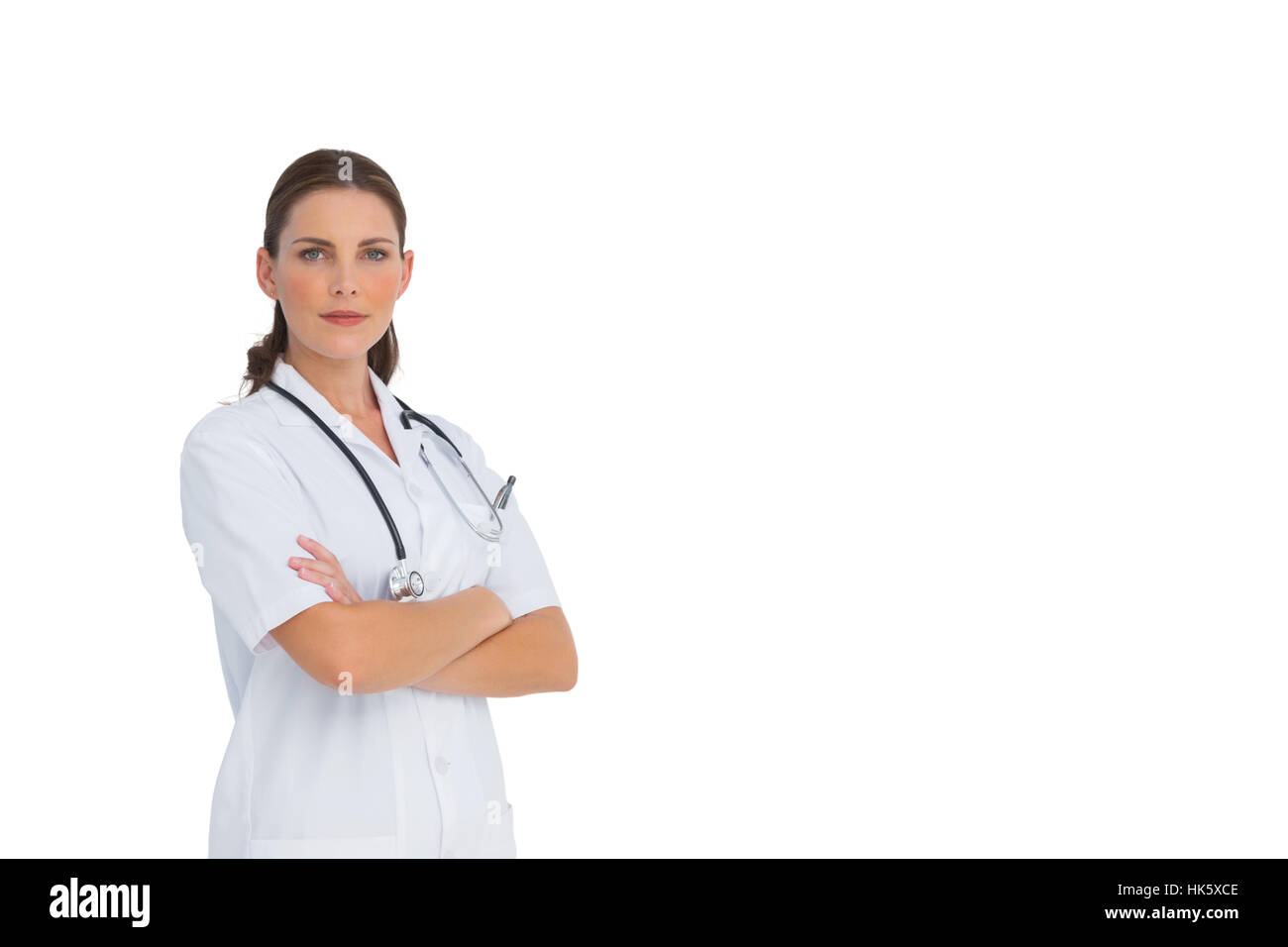Stern nurse with arms crossed on white background Stock Photo - Alamy