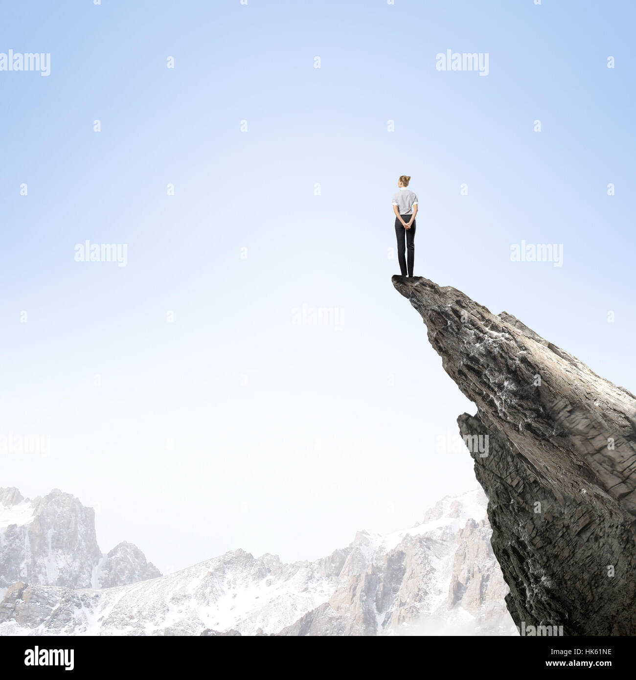 Attractive businesswoman standing on edge of mountain Stock Photo - Alamy