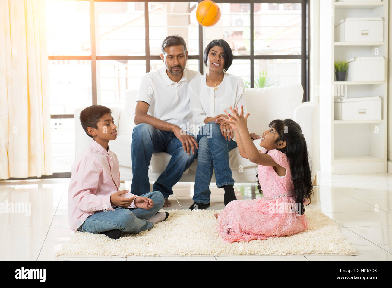 indian family playing with ball in living room Stock Photo - Alamy