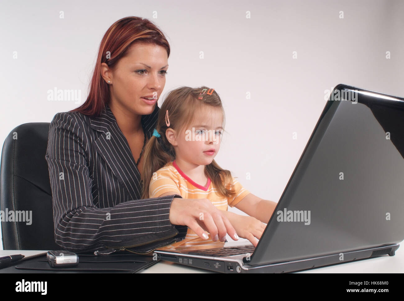 Business woman with child using laptop Stock Photo - Alamy