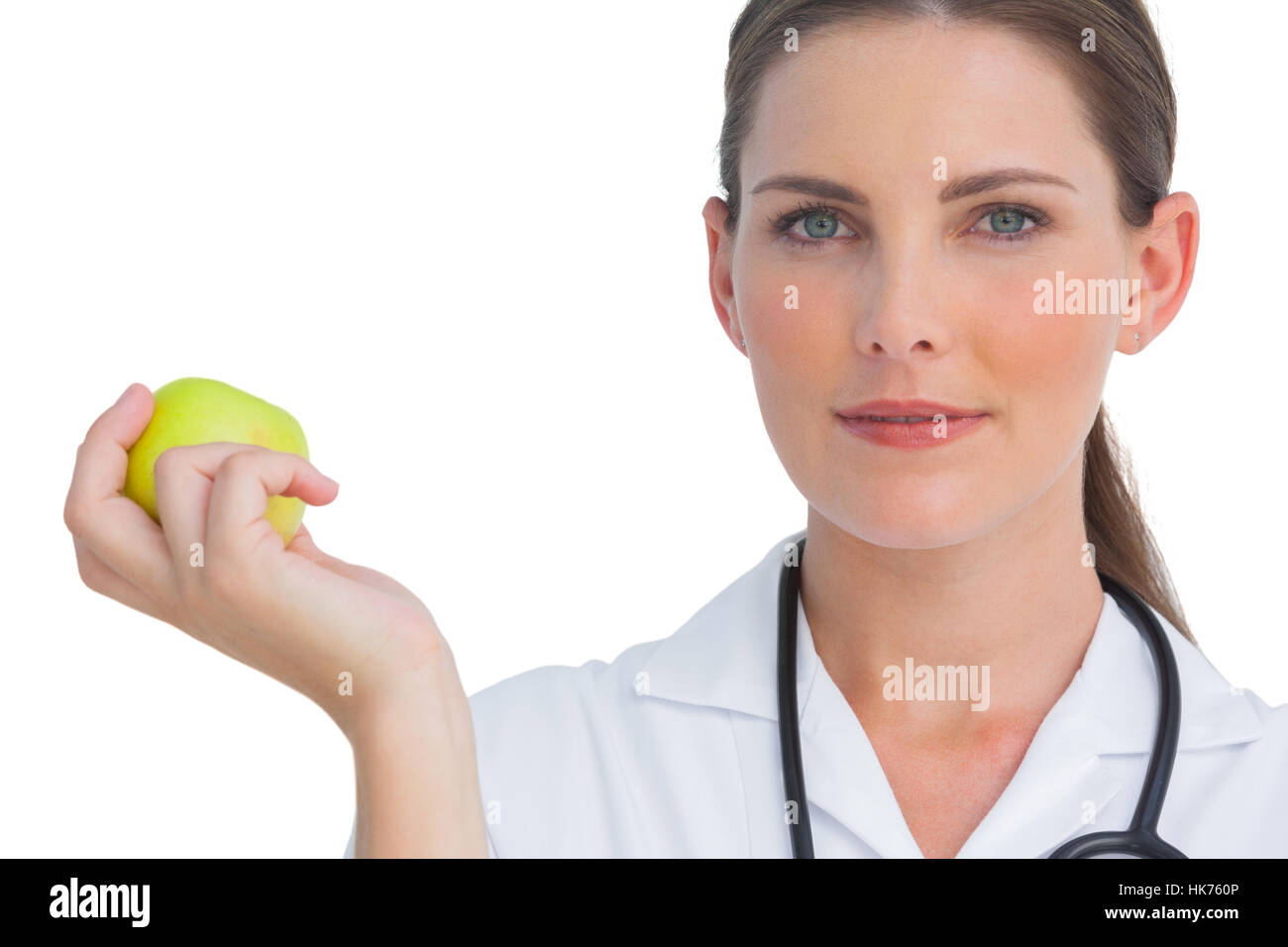 Nurse smiling and holding an apple on white background Stock Photo - Alamy