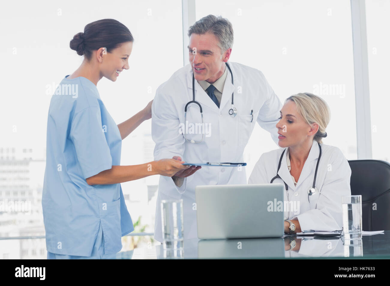 Nurse giving folder to her colleagues in the office Stock Photo - Alamy