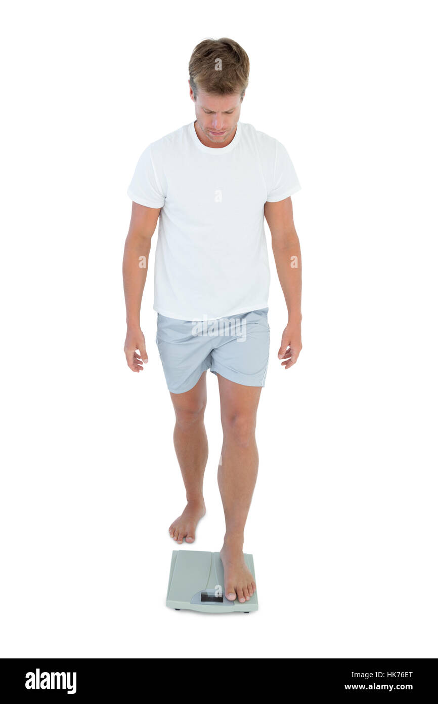 Handsome man getting on a weighing scale on white background Stock ...