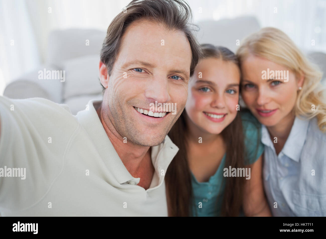 Portrait of a cute family in the living room Stock Photo - Alamy