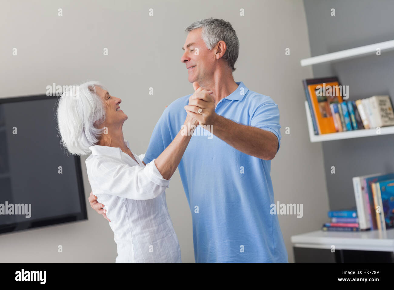 Elderly couple dancing together in the living room Stock Photo - Alamy