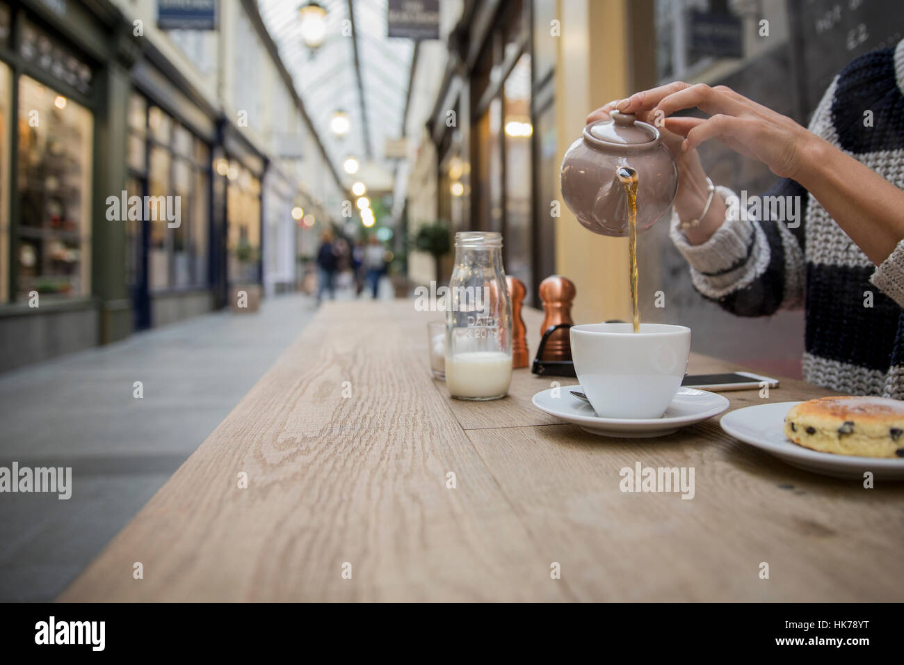 Tea is poured at a table outside a cafe in a shopping arcade in Cardiff ...