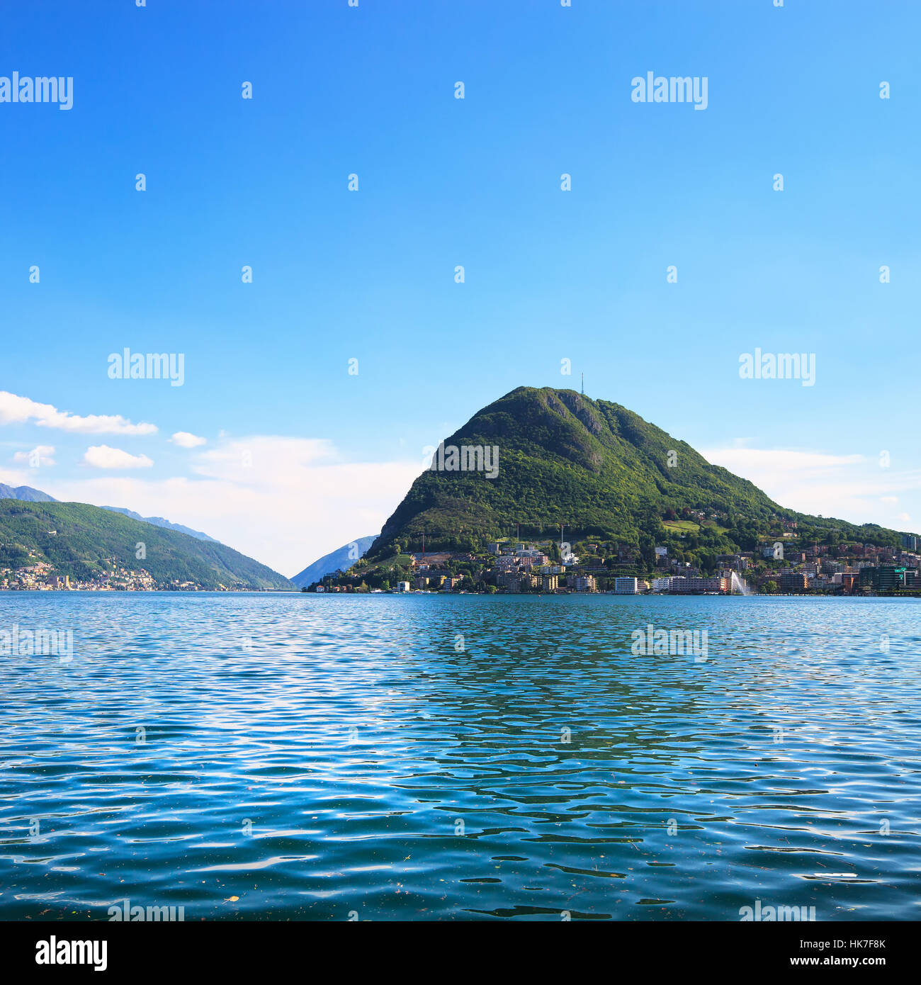 Lugano lake and mountains landscape. City, water, blue sky and ...