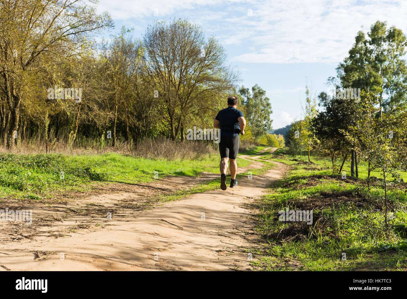 Big belly man jogging , exercising, doing cardio in the park , slightly ...