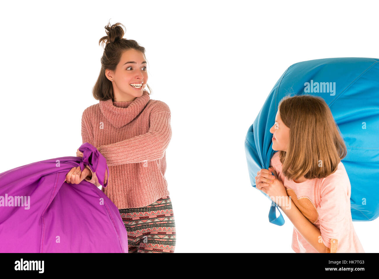 Young funny girls fighting with beanbag chairs isolated on white ...