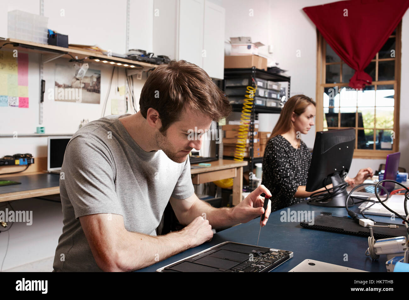 A young man and woman working at a bench in a technology lab Stock ...
