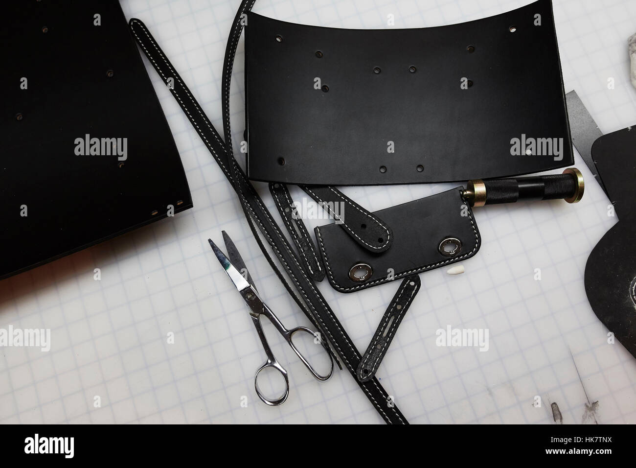 A handmade blue leather bag, strap, component part parts, scissors and ...