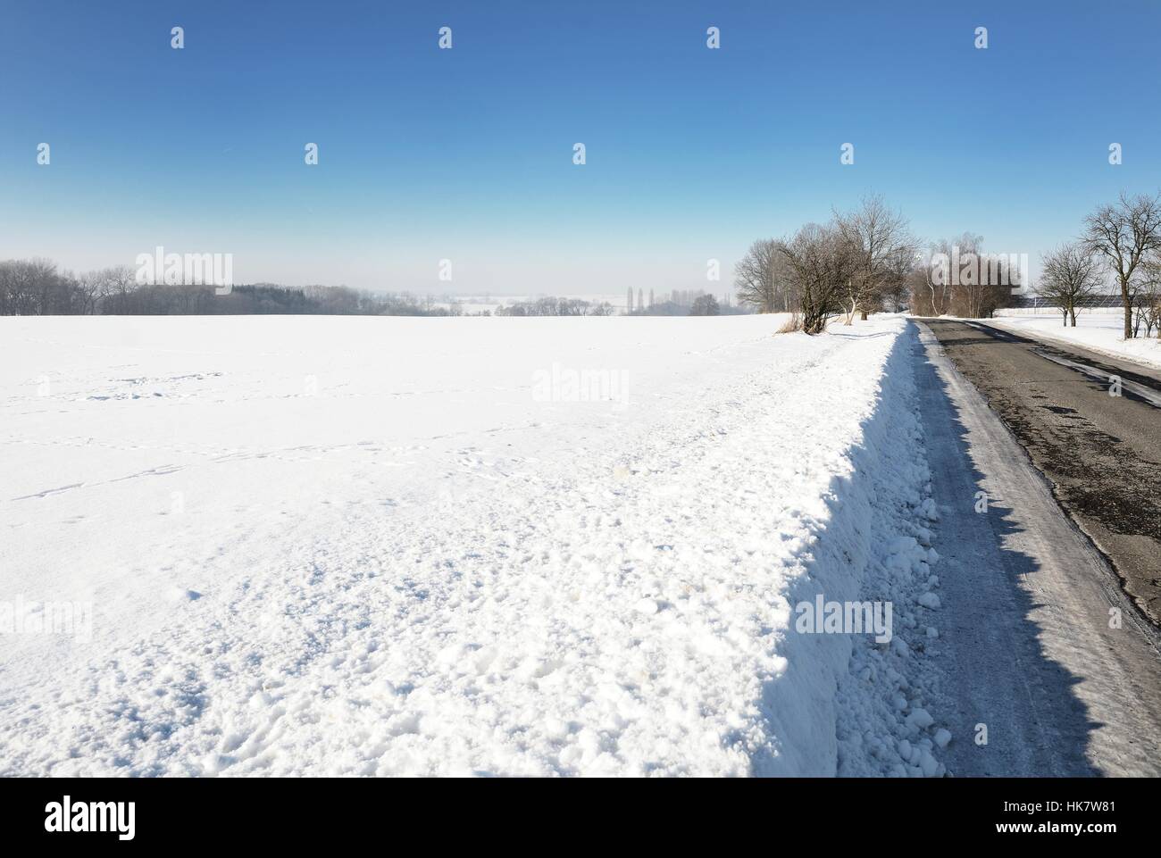 Rural winter scene with snowy field and road Stock Photo - Alamy