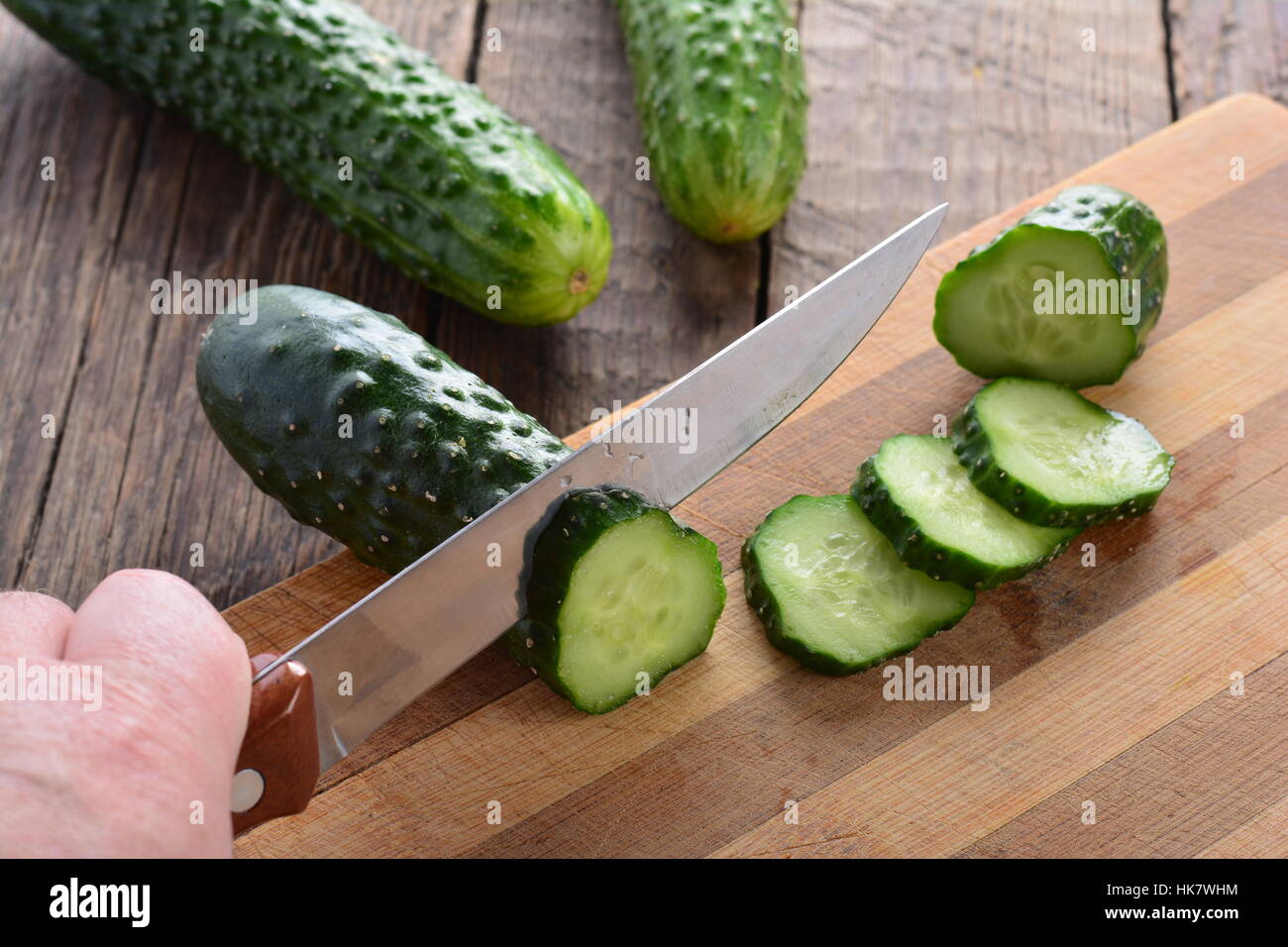 Cutting cucumber on a chopping board Stock Photo - Alamy