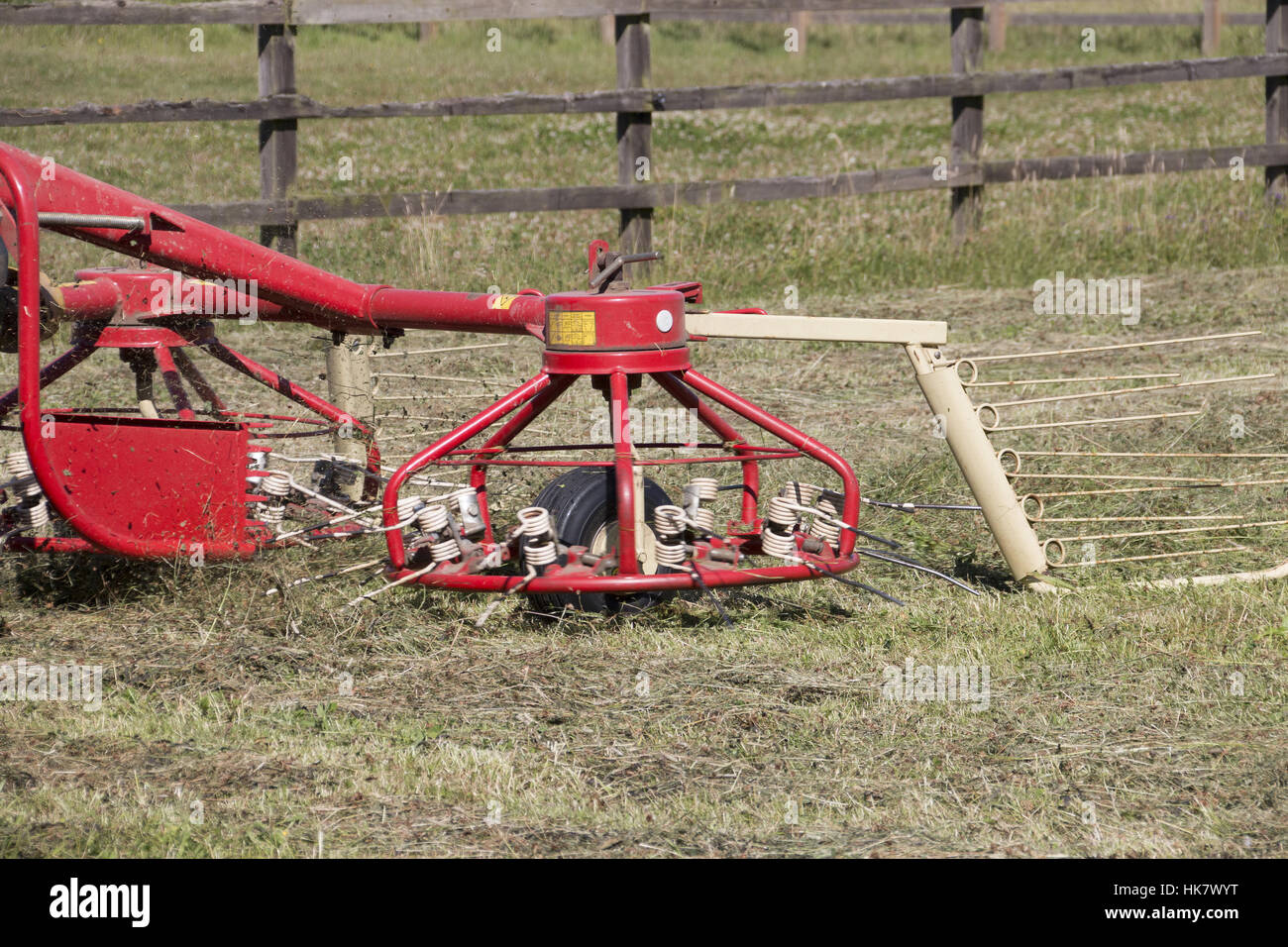 Haymaking, second stage, turning the cut grass using a twin rotor rake ...