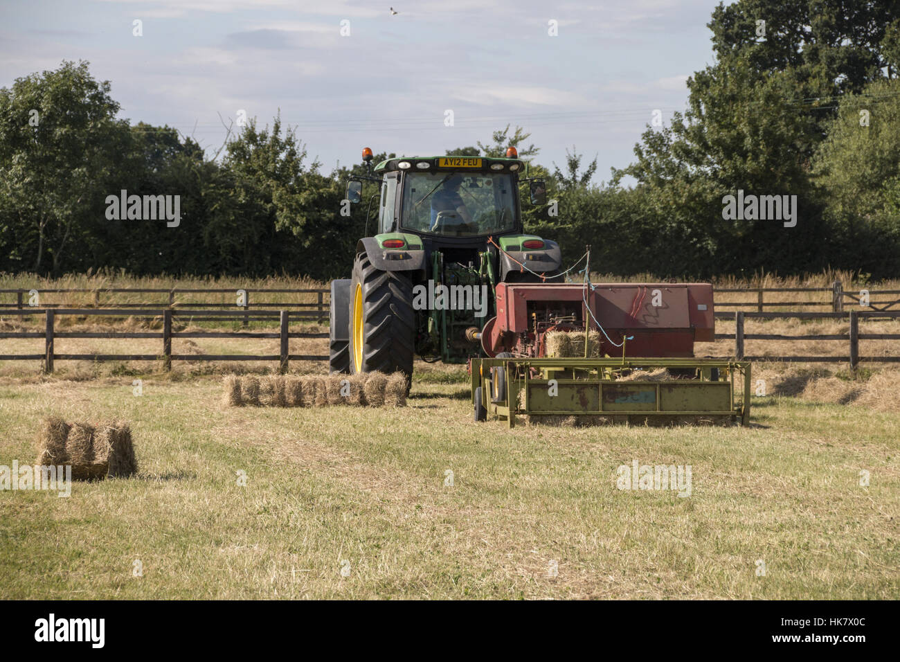 Haymaking, third stage, tractor towing conventional baler and bale ...